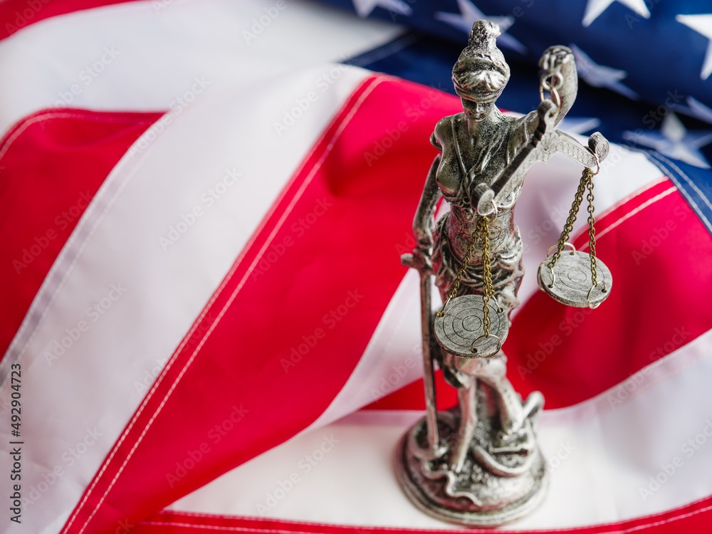 Statue of themis on background of flag of America or United States ...