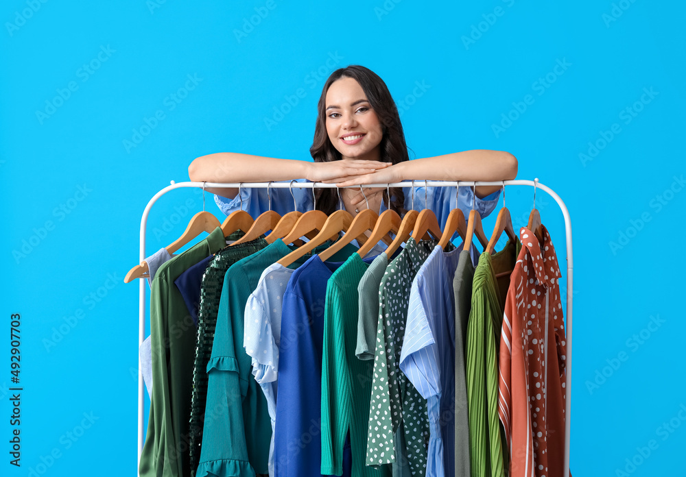 Beautiful young girl near rack with clothes for high school prom on ...