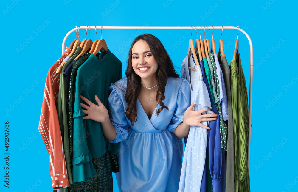 Beautiful young girl near rack with clothes for high school prom on ...