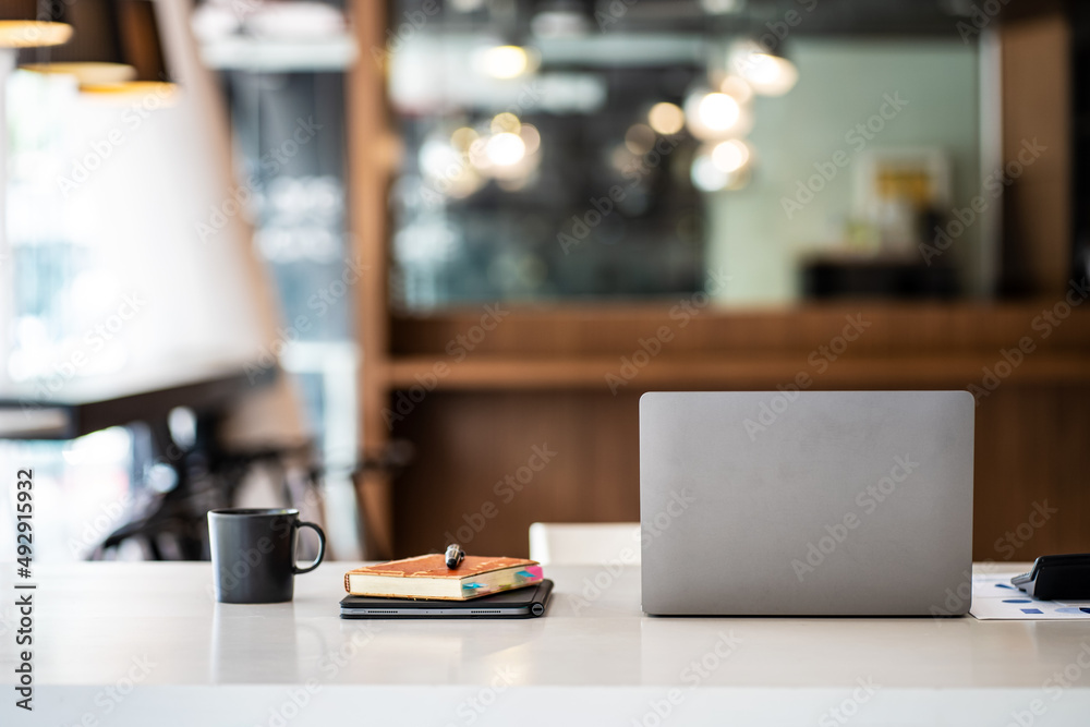 Simple workspace laptop and notebook on white table with blurred office ...