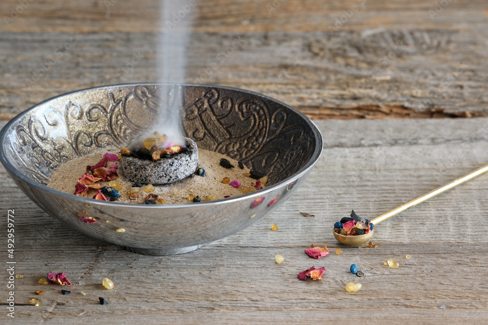Aromatic frankincense resin (Boswellia) and rose blossom petals burning ...