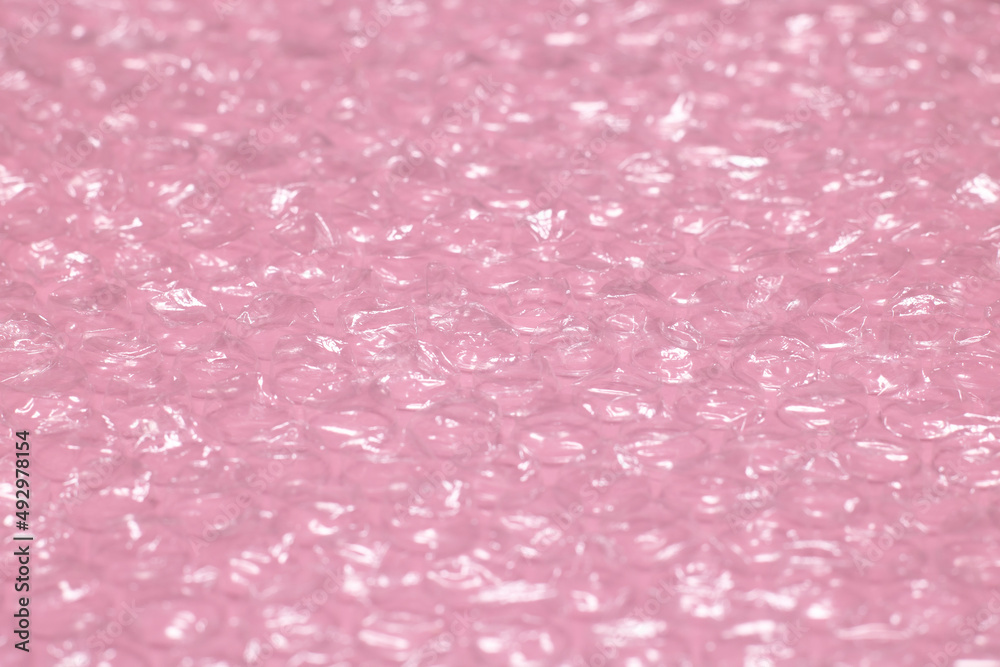 Pink background of polymer packaging material, layers of smooth and ...