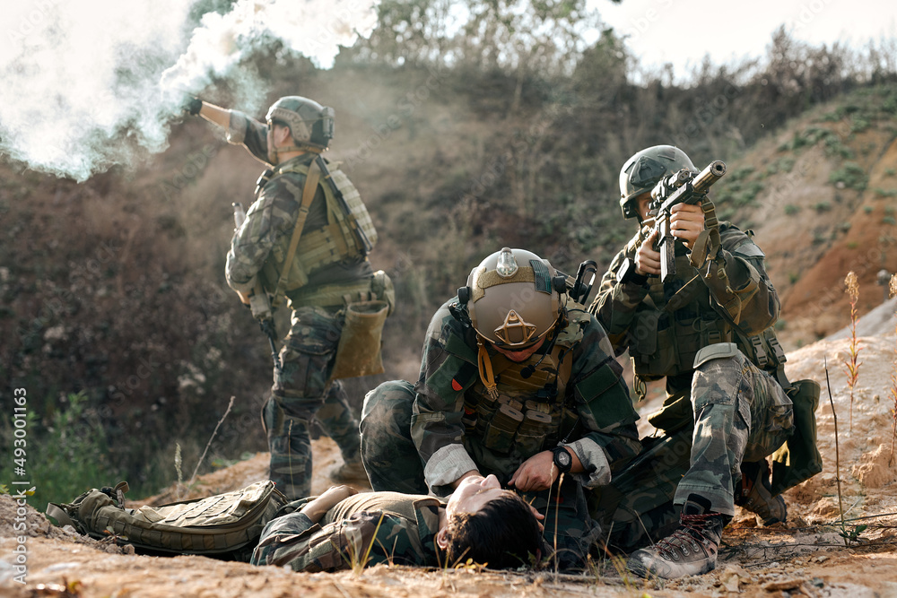 responsive army soldiers with injured comrade calling for help, blowing ...