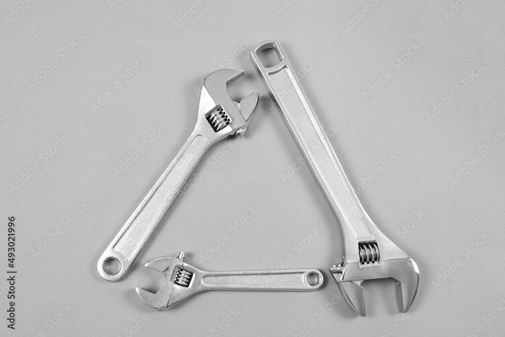 Adjustable steel keys lie in the shape of a triangle on a gray ...