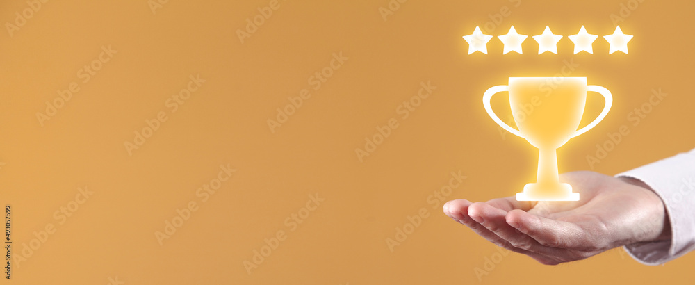 Man holding winner trophy cup and five stars. Stock Photo | Adobe Stock