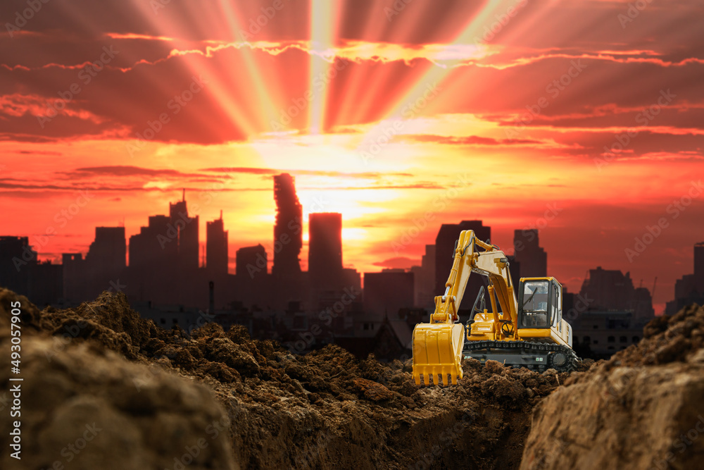 Excavators are digging the soil in the construction site on the sunset ...