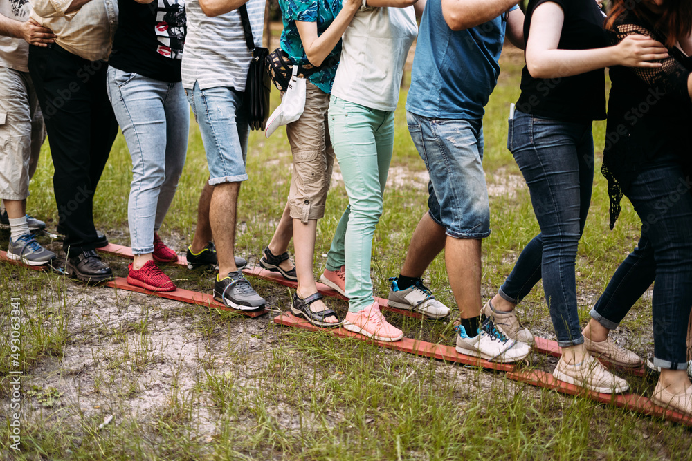 People with their feet tied together doing a team building exercise in ...