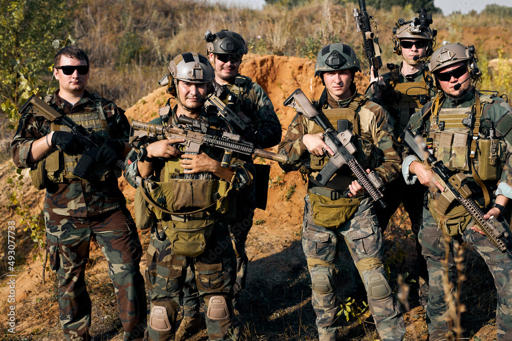 military men, group of soldiers posing at camera carrying rifle guns ...