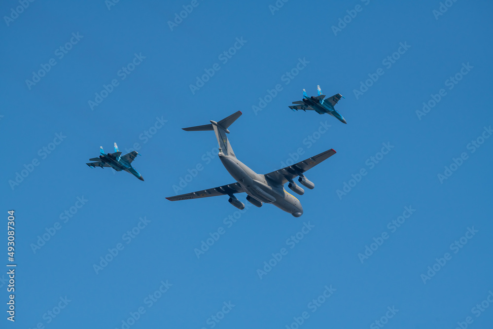 IL-76 aircraft with two su-27 fighters of ukrainian army flying in blue ...