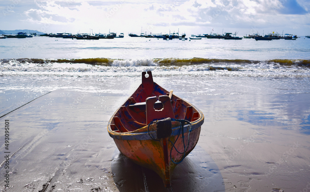 Traditional wooden fishing boats and beautiful hilly beach in East Java ...
