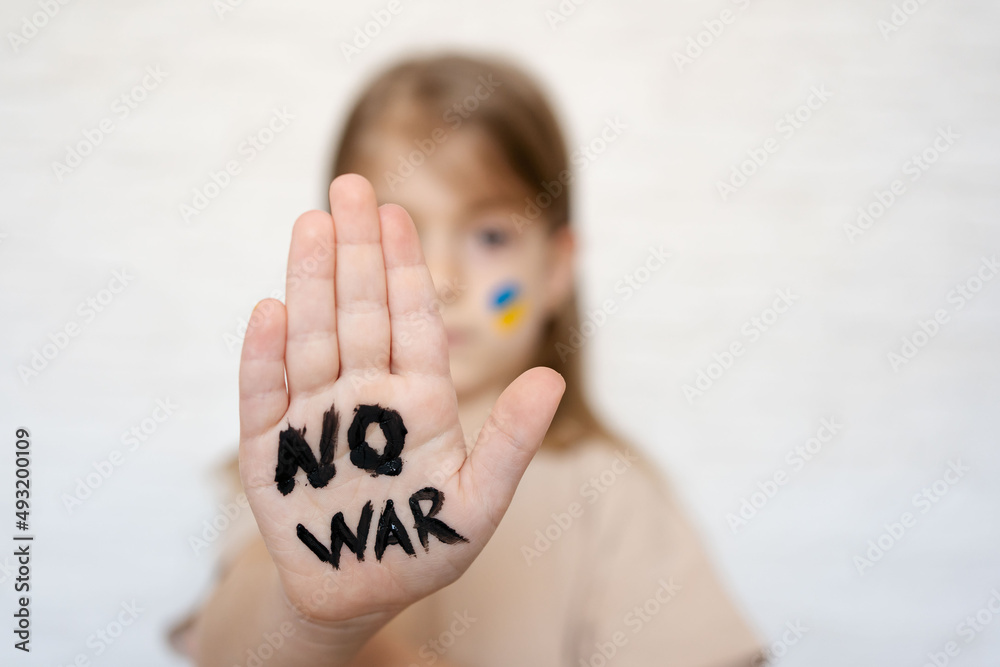 Child with messege of peace without war is written on the child's hand ...