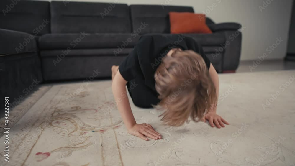 The boy is pushing up from the floor at home. Quarantine and sport ...