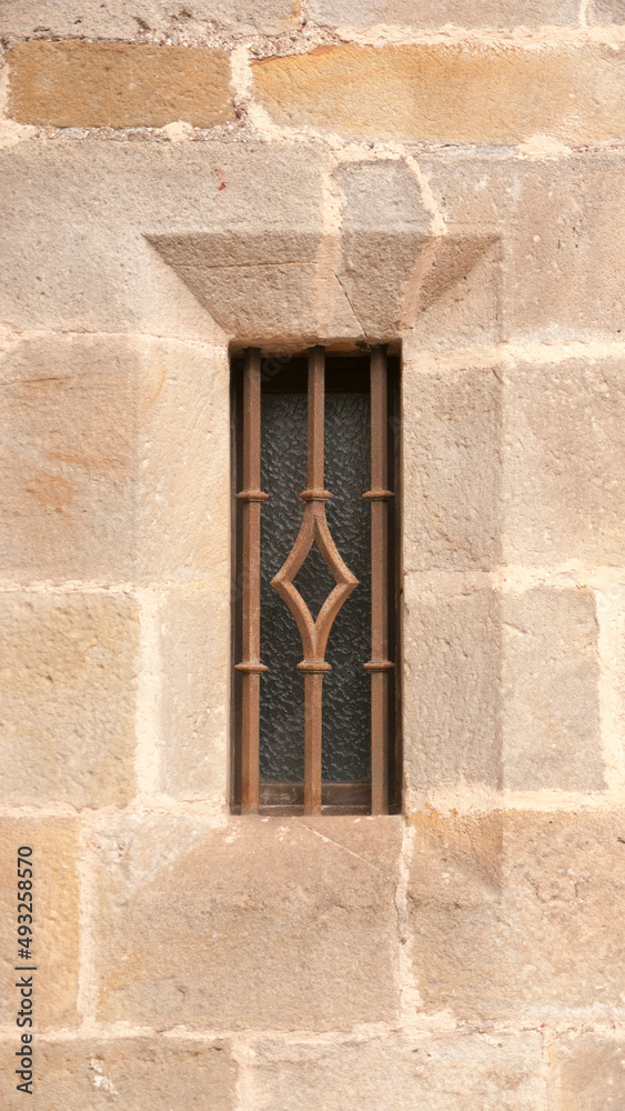 Ventanuco con reja en pared monumental de iglesia medieval Stock Photo ...
