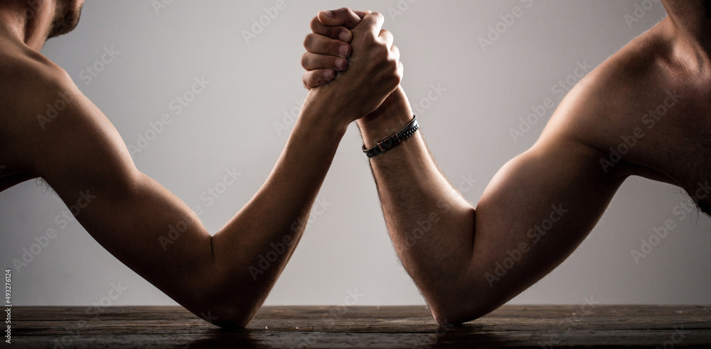 Heavily muscled bearded man arm wrestling a puny weak man. Arms ...