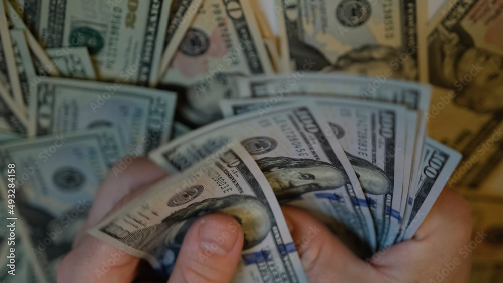 Male hands counting American one hundred dollar bills against the ...