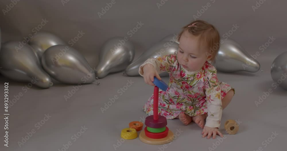 Using wooden ring stacker. Baby girl playing with pyramid educational ...