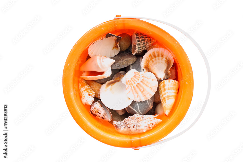Seaside shells and pebbles in plastic orange bucket from above Stock ...