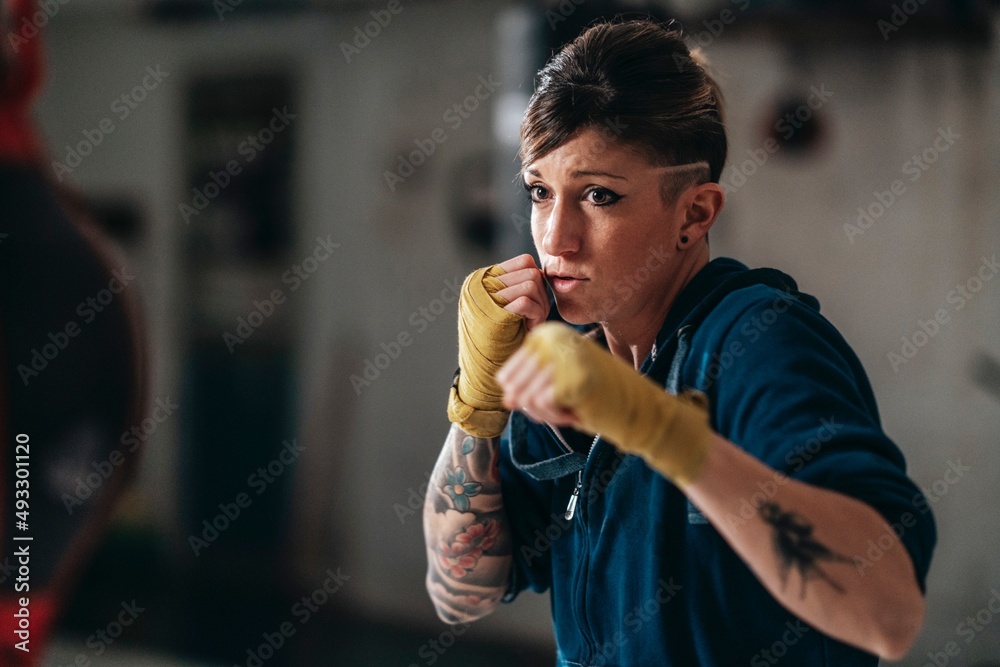 Female boxer punching boxing bag Stock Photo | Adobe Stock