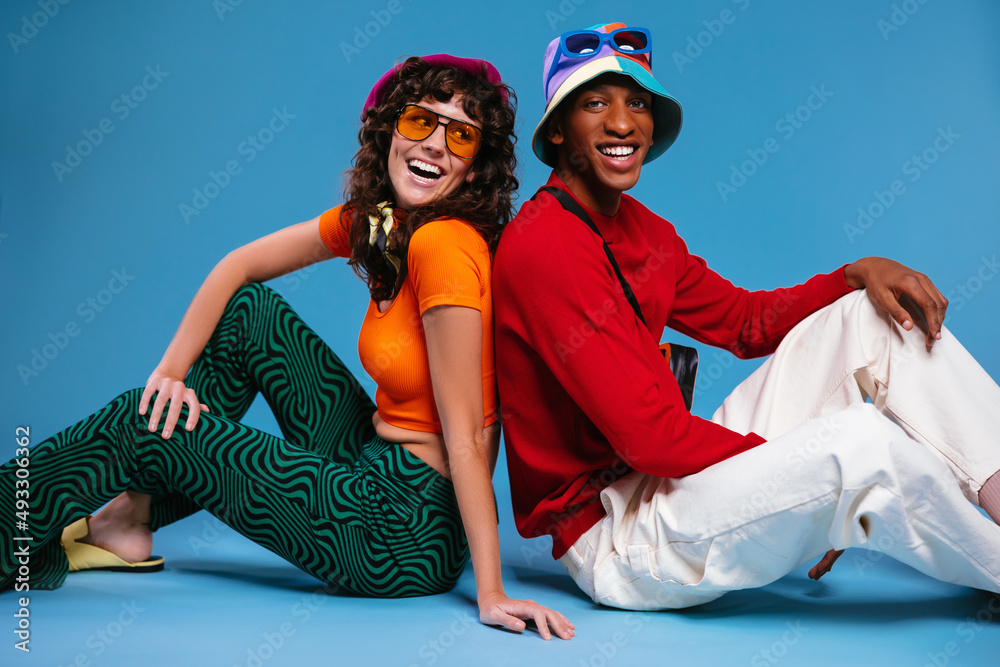 Trendy models sitting back to back Stock Photo | Adobe Stock