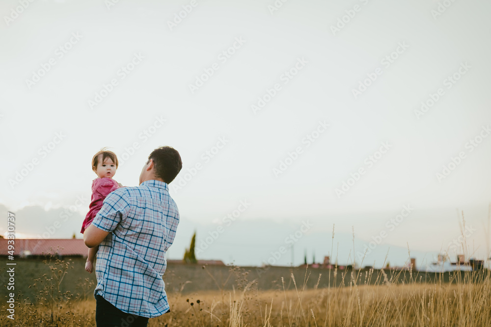 Mexican dad carries and plays with daughter in his arms - Young father ...