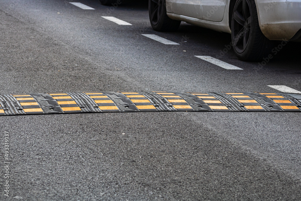 Traffic safety speed bump on an asphalt road in a parking area in ...