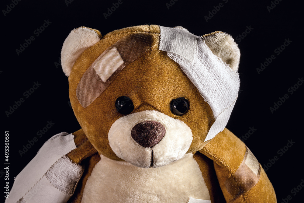 closeup of teddy bear bandaged with bandages and band aid, concept of ...
