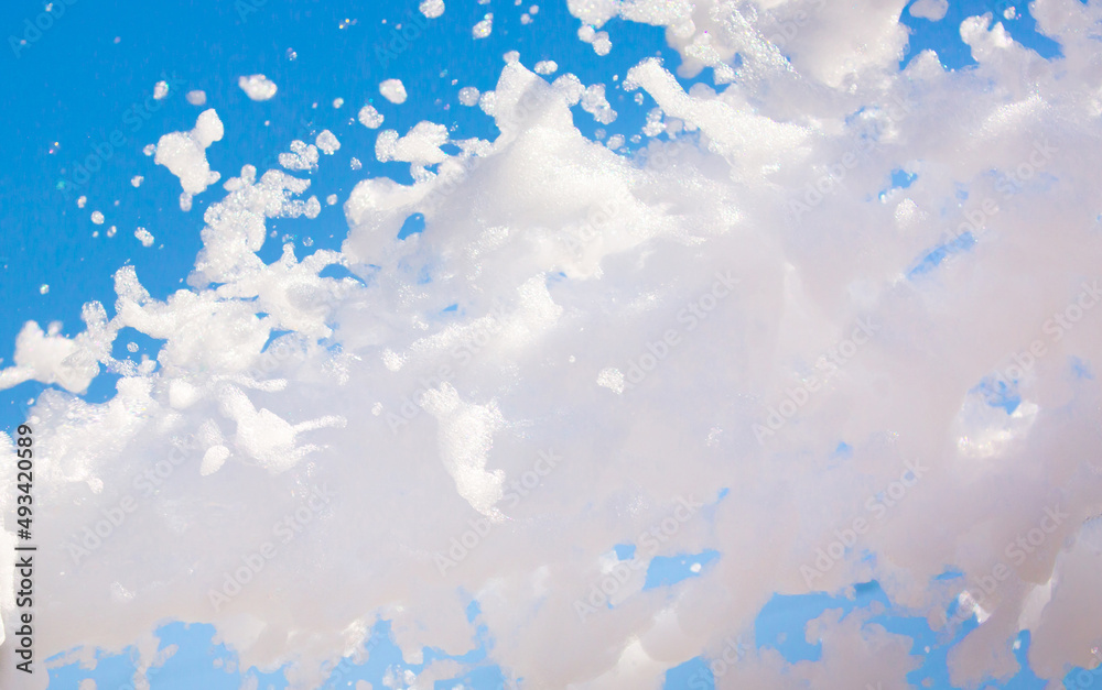 White soap foam on a blue sky background. Fun foam, background or ...