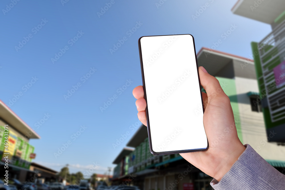 White blank touch screen smartphone holding in hand with blurr modern ...
