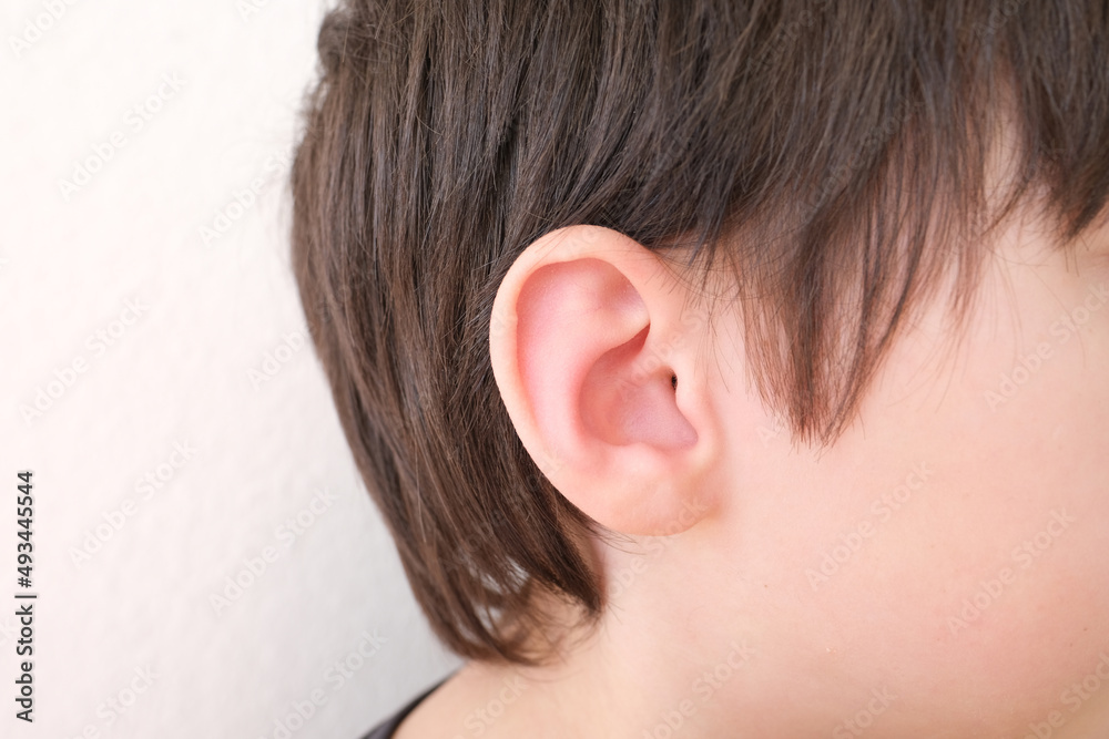 part of child's face in profile, a boy of 10 years old touches sore ear ...