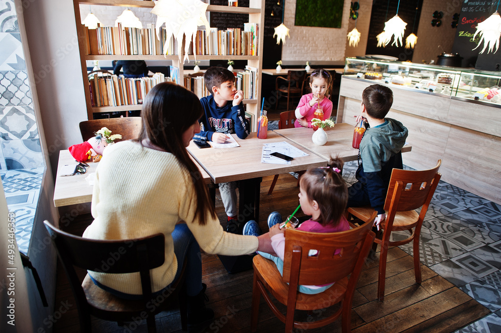 Mother with four kids spending time in cafe. Family lunch in the ...