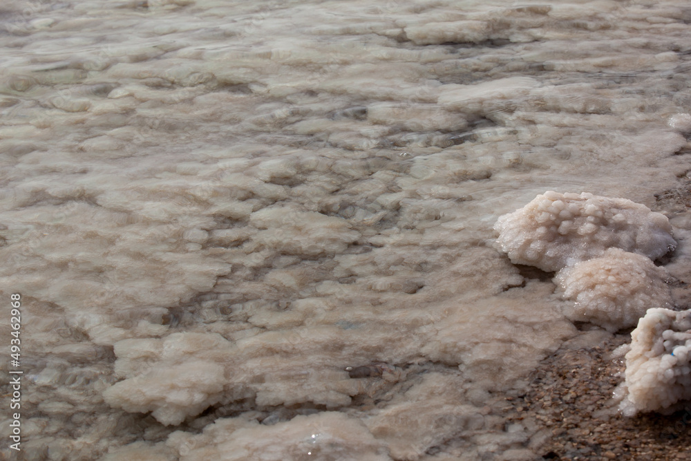 Huge layer of salt and conbles on a bottom of the dead sea near coast ...