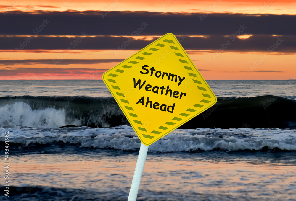 Sign with text 'Stormy Weather Ahead' on the background of the sea with ...
