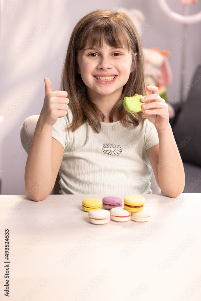 Attractive scholl girl bites a macaroon, surprised with taste ...