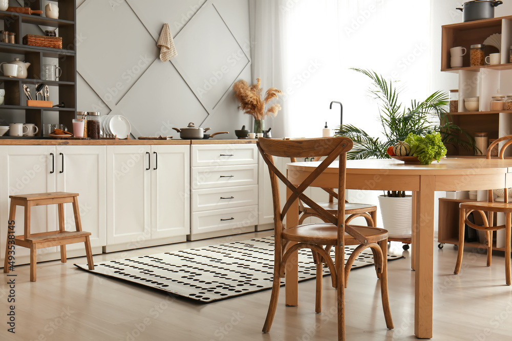 Interior of modern kitchen with white counters, shelving units and ...