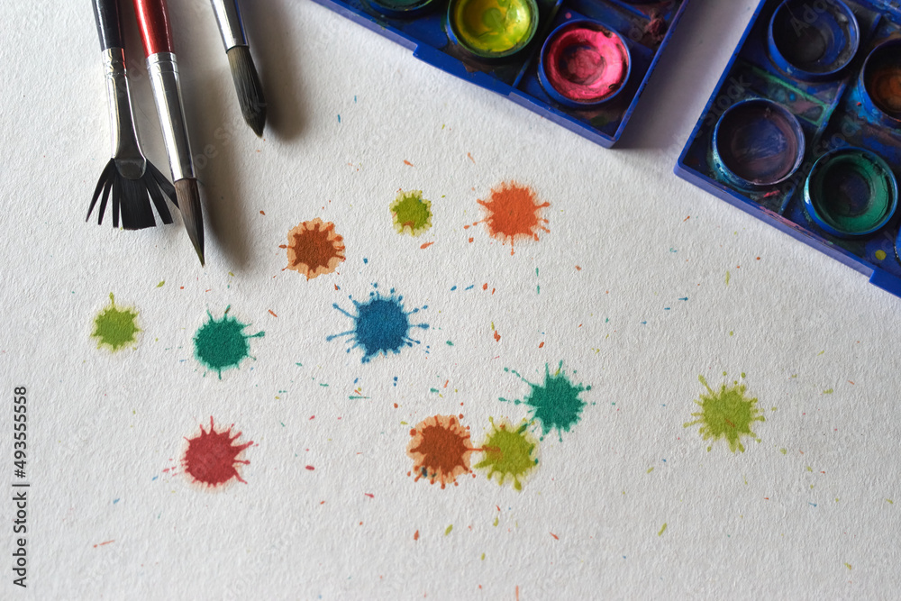 Paintbrushes with the color palettes and the color stains on the rough ...