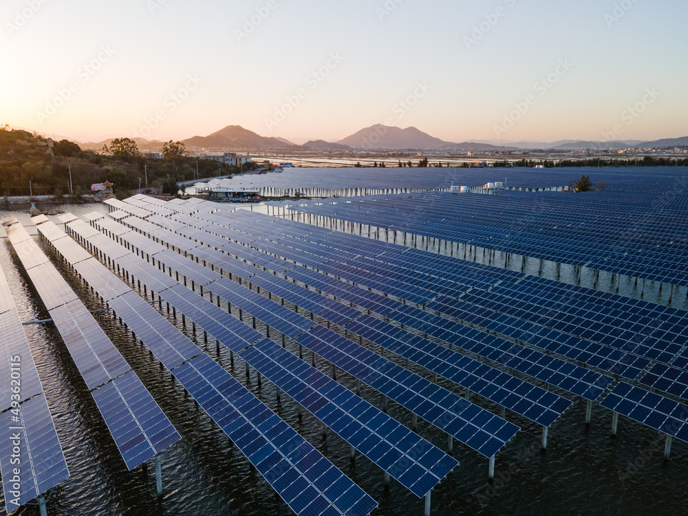 An aerial view of a solar power plant in the sea at sunset.New Energy ...