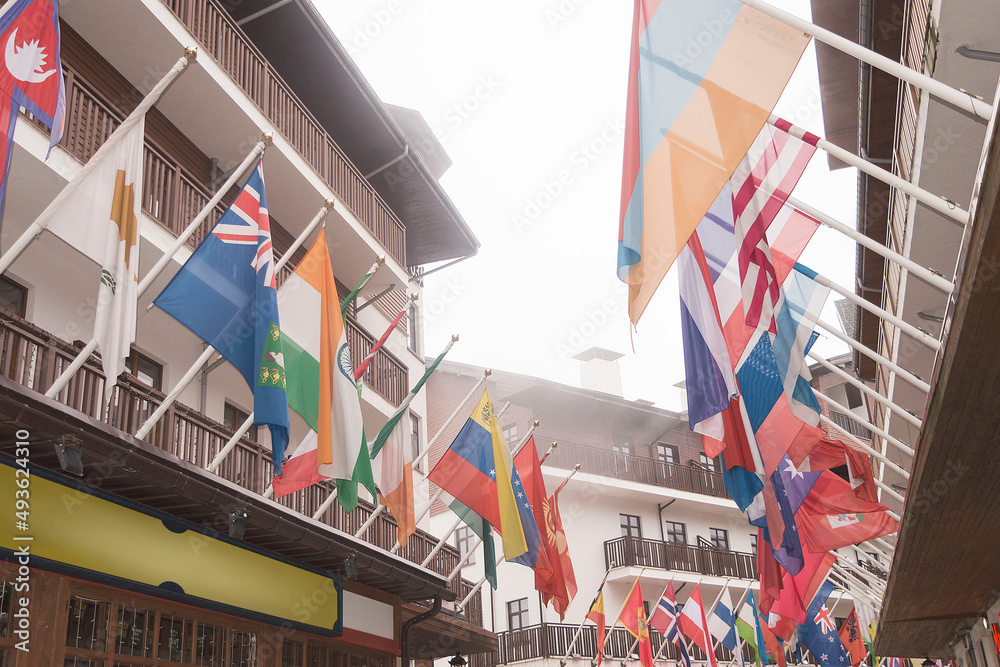 View of buildings facades with multiple national flags of different ...