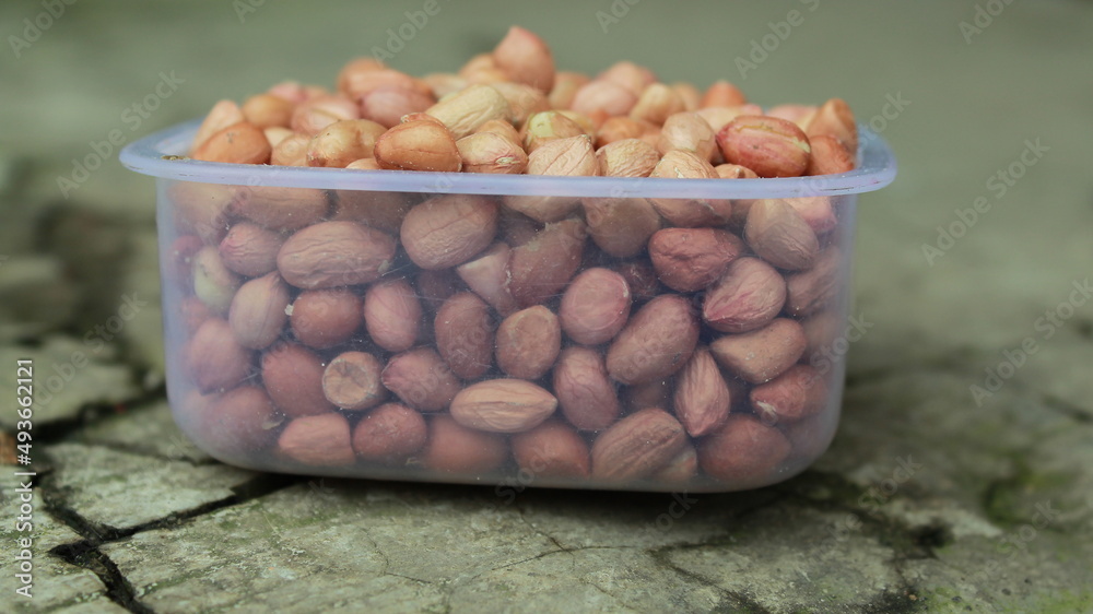 Salted Roasted Peanuts, Peeled raw peanuts are in a plastic cup ...