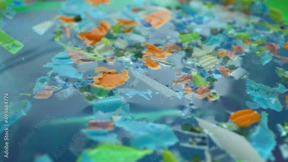 Microplastics floating on the sruface of polluted water. Concept of ...