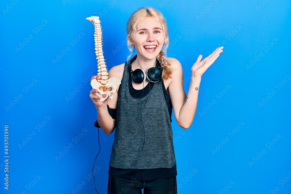 Beautiful caucasian sports woman with blond hair holding anatomical ...