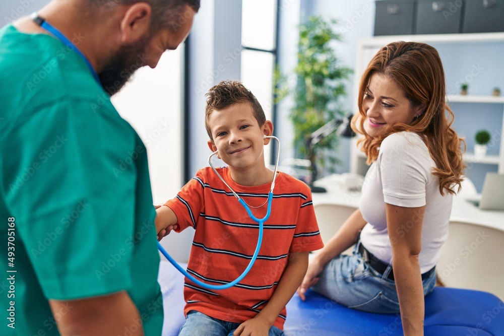 Family having medical consultation child auscultating doctor heart at ...