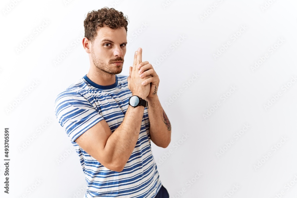 Handsome young man standing over isolated background holding symbolic ...