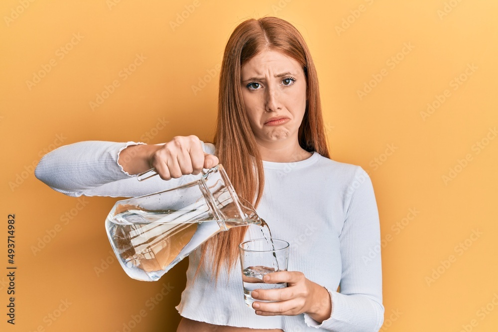 Young irish woman pouring water depressed and worry for distress ...