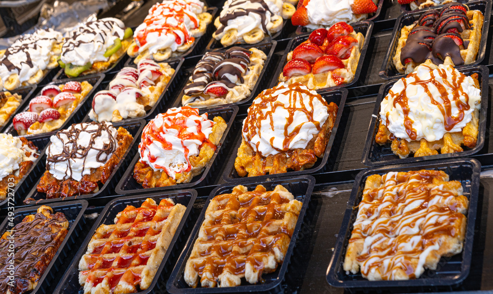 Delicious traditional Liege waffles with colorful toppings on display ...