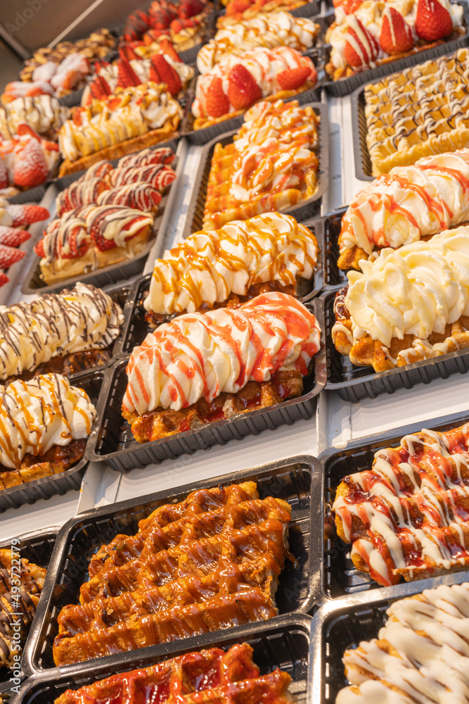 Delicious traditional Liege waffles with colorful toppings on display ...