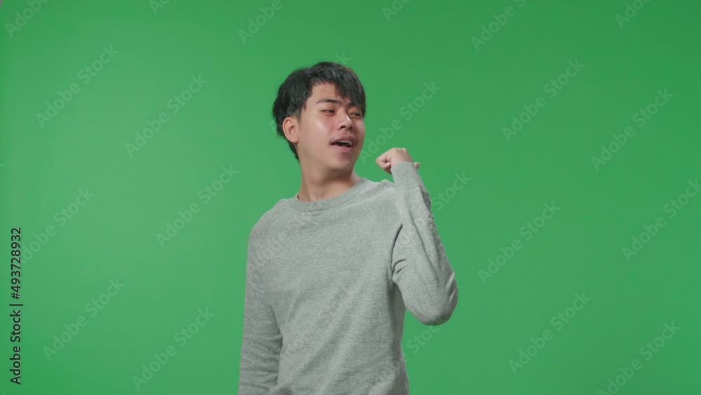 Side View Of A Smiling Asian Man Pointing To The Back Behind By Thumbs ...