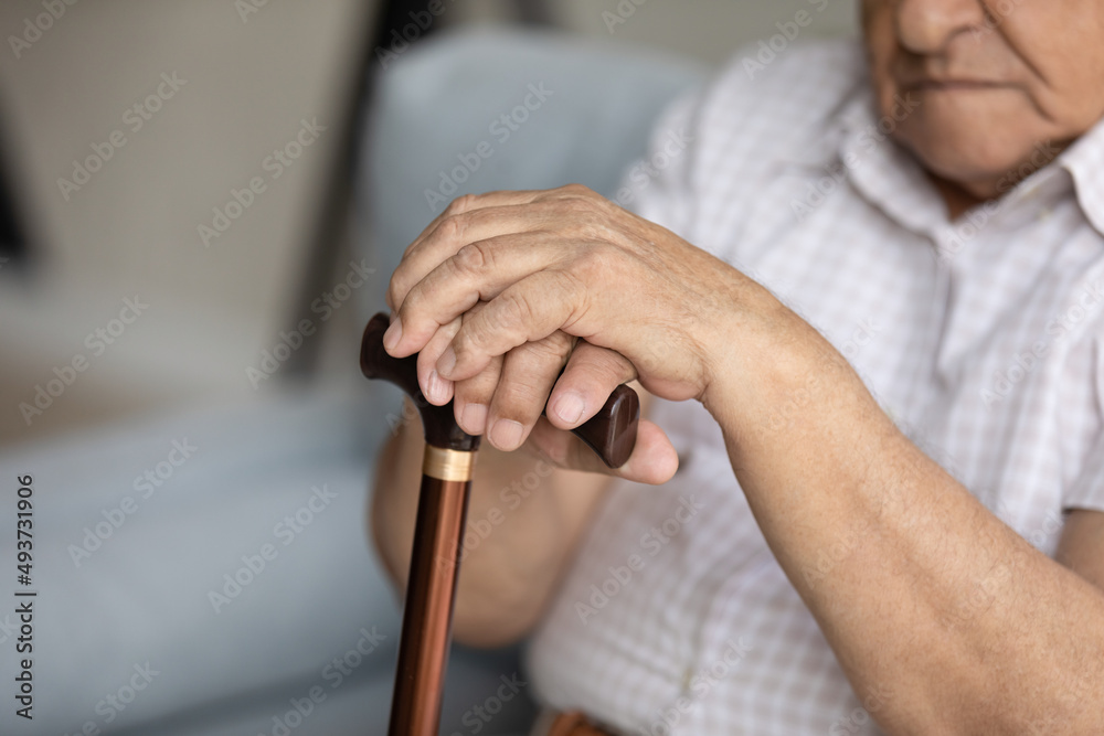 Close up cropped view disabled older man holds cane looks desperate or ...