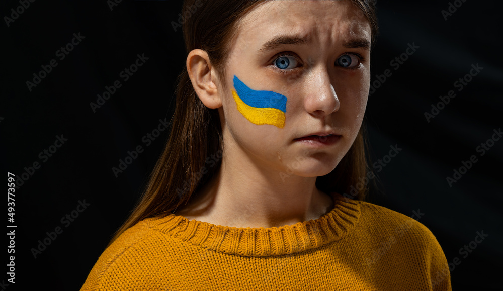 Flag of Ukraine painted on a face on the face of a teenage child. War ...