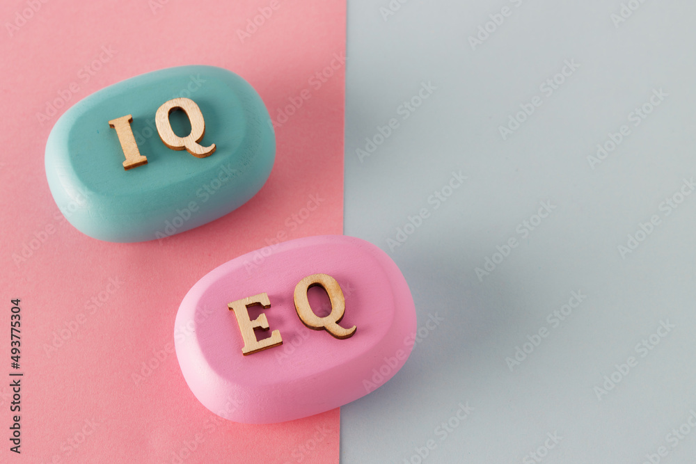 IQ and EQ letters symbols. Wooden signs on blue and pink background ...