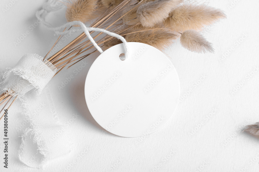 Round white tag mockup on a white background with cotton string and ...